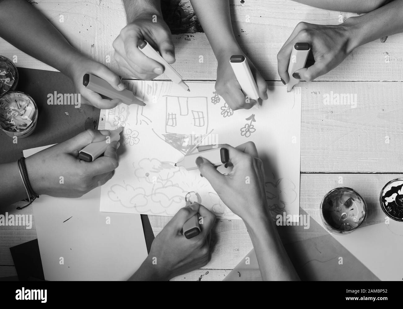 Markers in male and female hands draw on white paper. Artists wooden ...