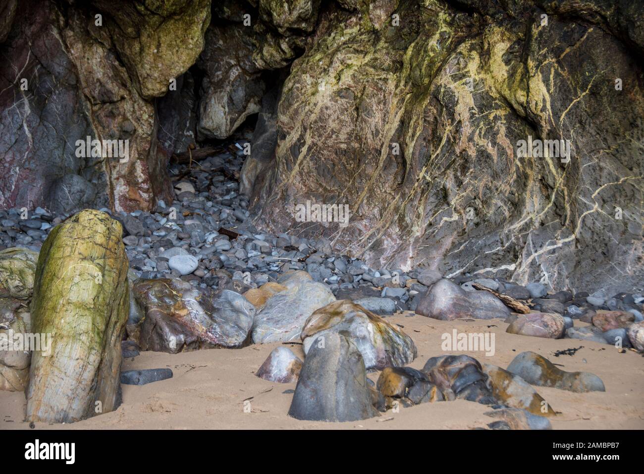 Detail of the rocks and pebbles heaped at the rear of a small cave at ...