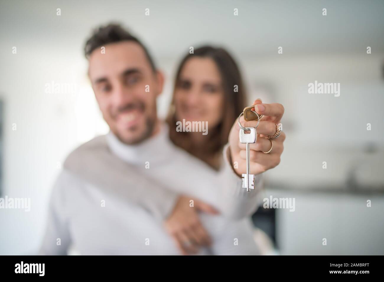 Happy couple showing the keys of their new house Stock Photo - Alamy