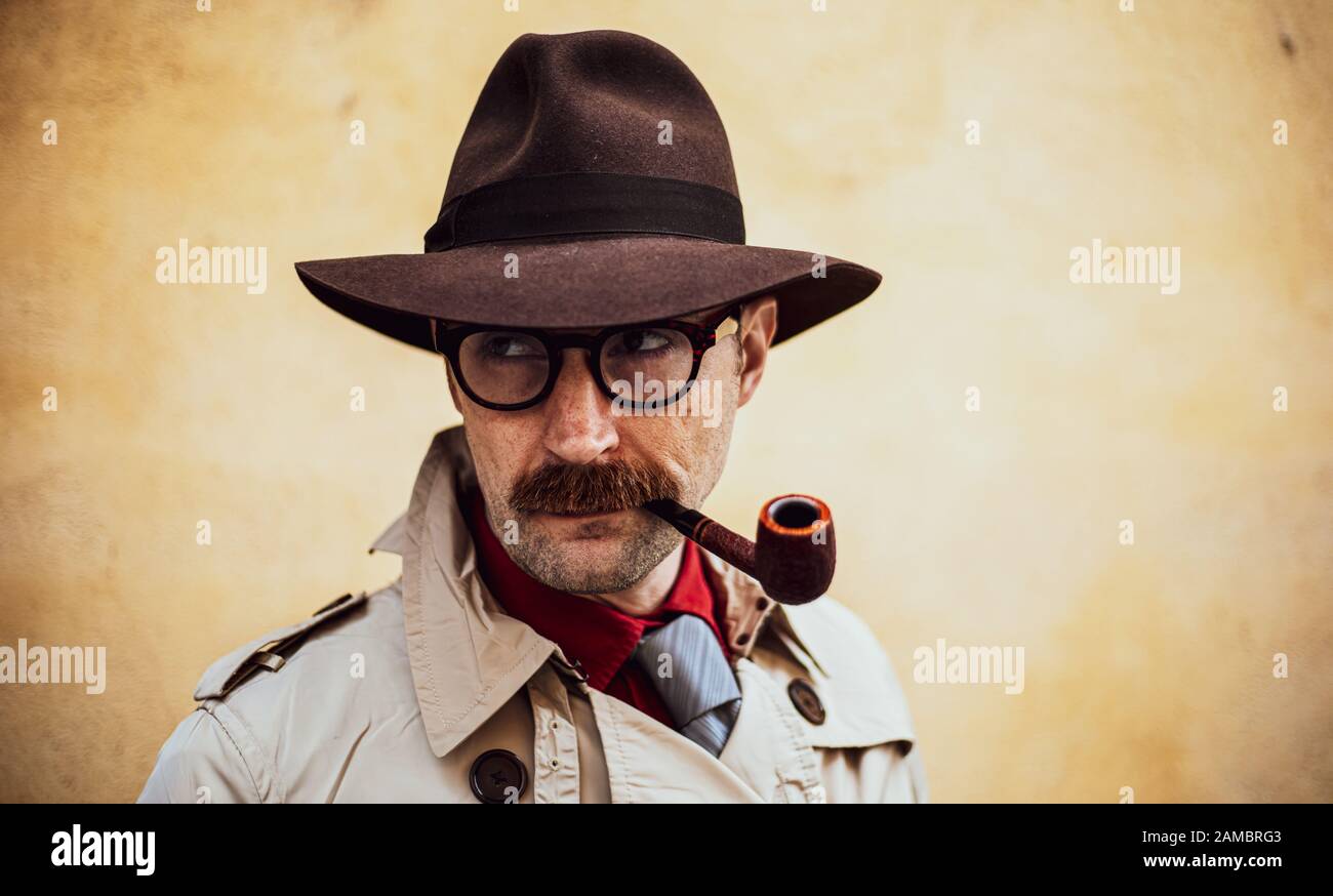 Vintage detective smoking a pipe outdoor in a grungy environment Stock ...