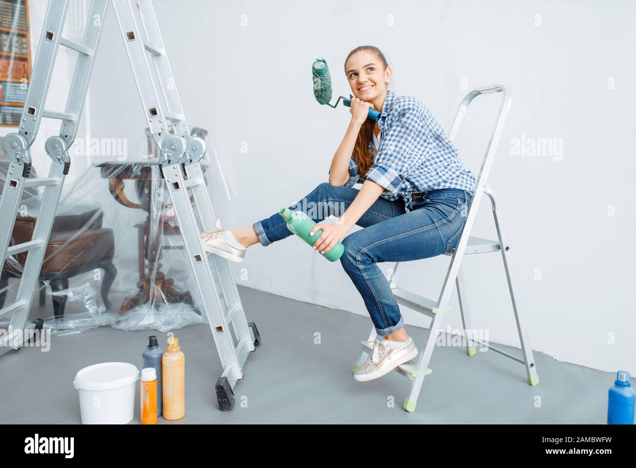 Female house painter sitting on a ladder Stock Photo - Alamy