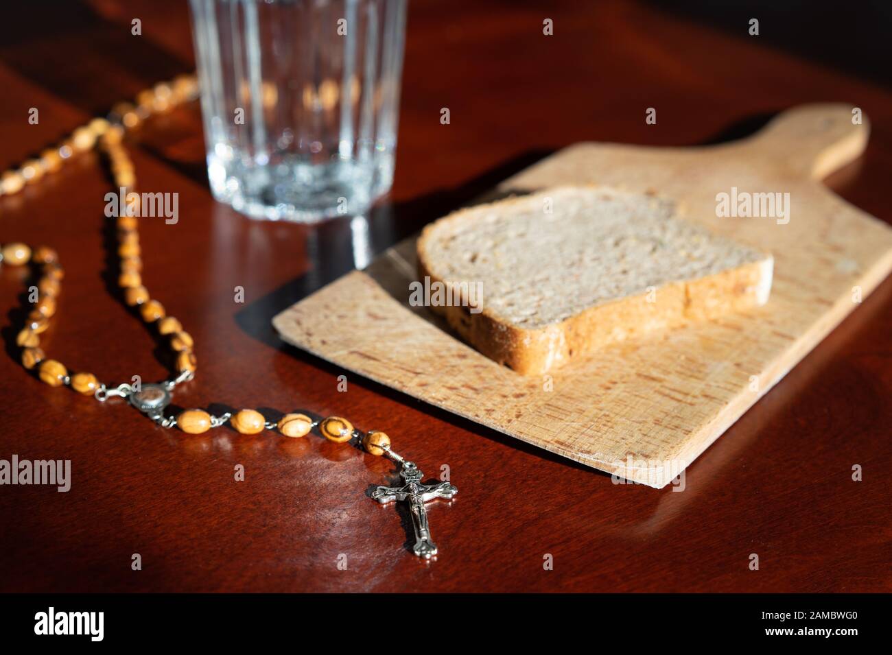 bread and water lent before easter with rosary beads Stock Photo - Alamy