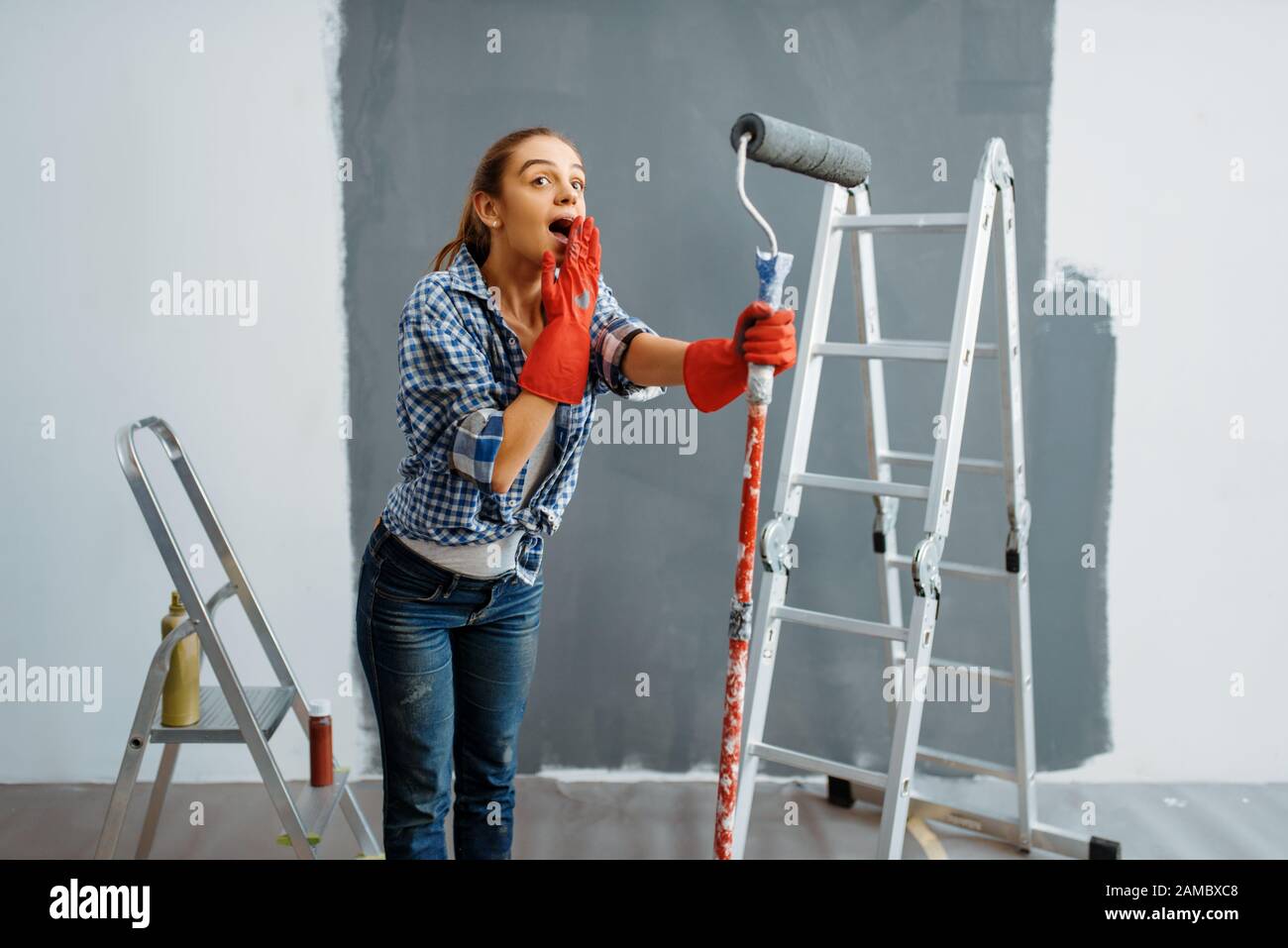 Surprised young woman makes home repair Stock Photo - Alamy