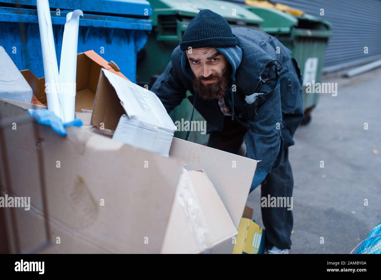 Bearded homeless searching food in trashcan Stock Photo - Alamy