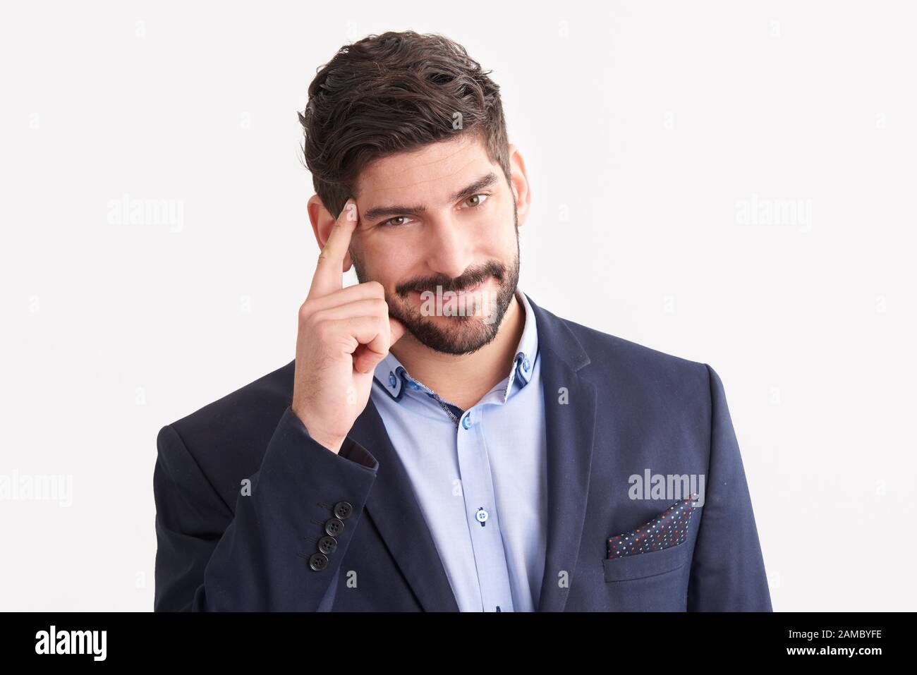Studio portrait of young businessman with hand on his forehead looking ...