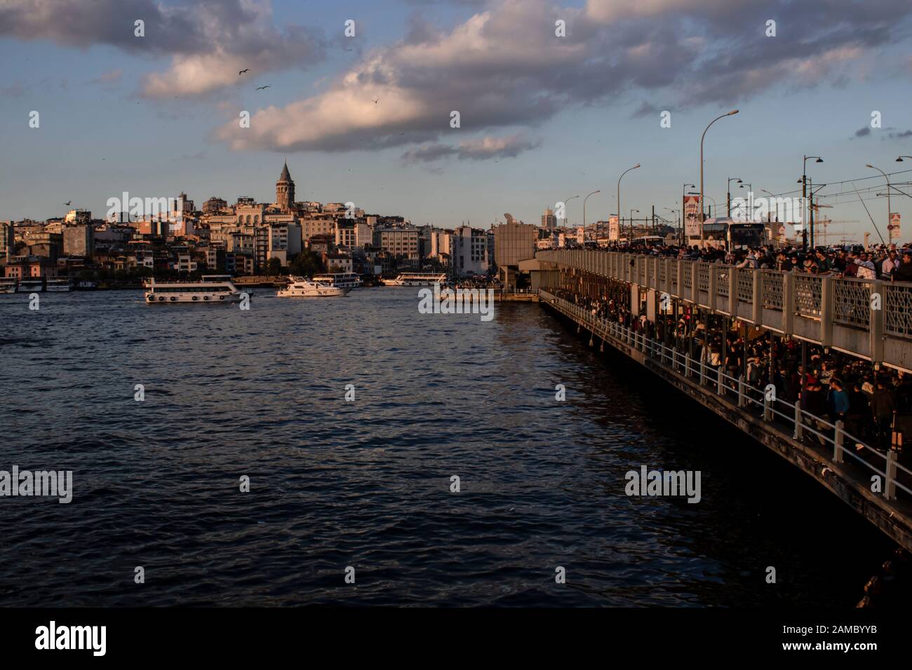 Galata Tower and Galata Bridge were taken together. People fishing on ...