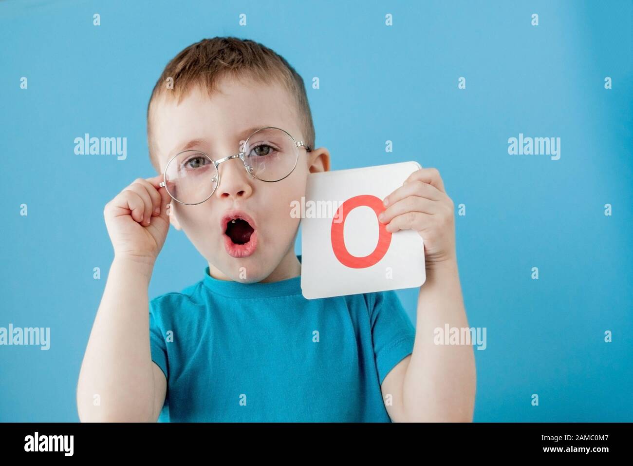 Cute little boy with letter on blue background. Child learning a ...