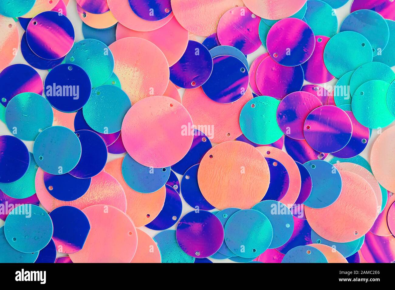 Big holographic sequins on pale orange background Stock Photo - Alamy