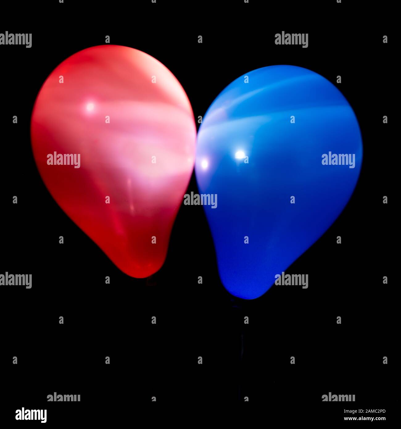 Red and blue balloons illuminated with LED against dark background ...