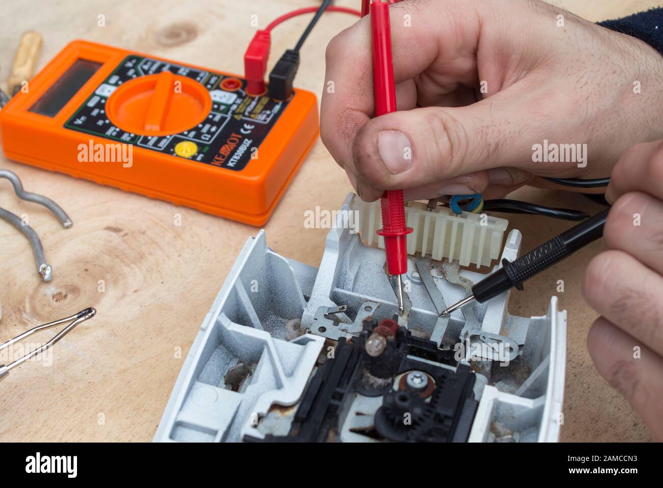 The hands of the electrician check the broken iron with the meter Stock ...