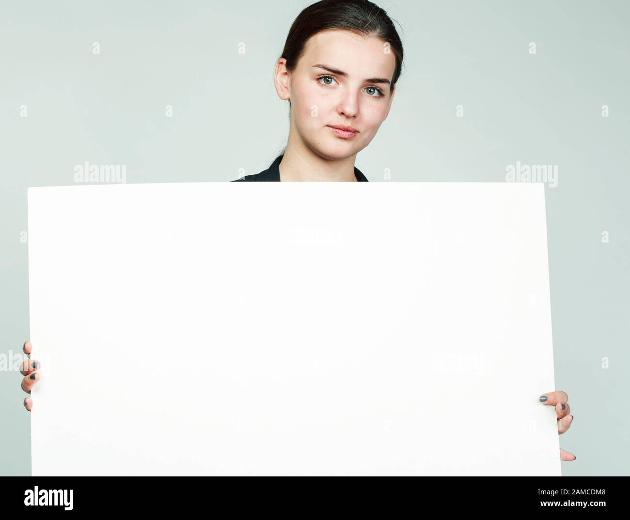 young pretty brunette girl with placard on white background wearing ...