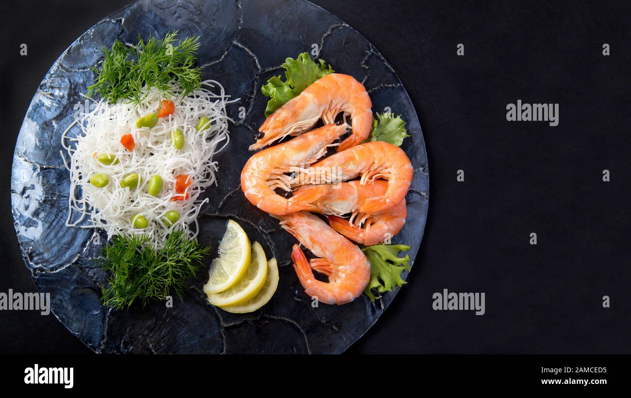 group of cooked king prawns on a blue shell plate background with ...
