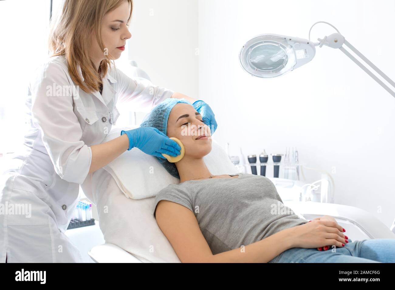 A woman, a professional doctor, a beautician cleanses the patient's ...
