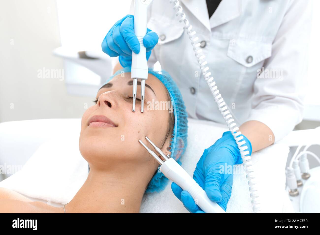 Portrait of a young beautiful girl face microcurrent therapy procedure ...
