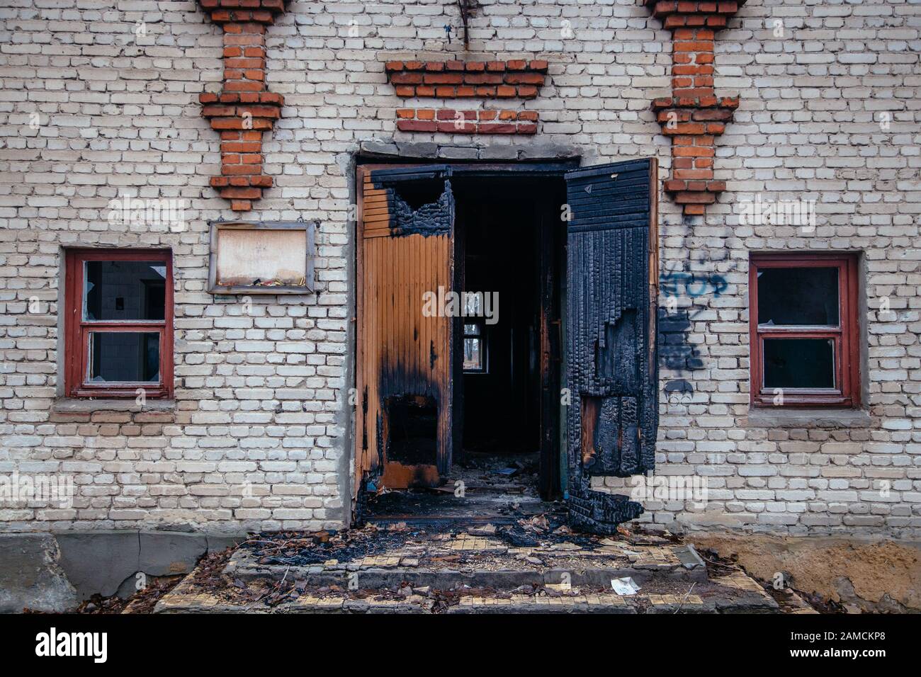 Consequences of fire. Burnt brick house. Burned entrance door Stock ...