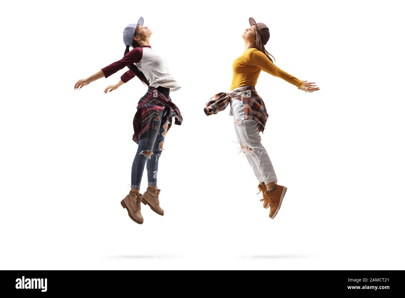 Full length profile shot of a young women performing a dance jump ...