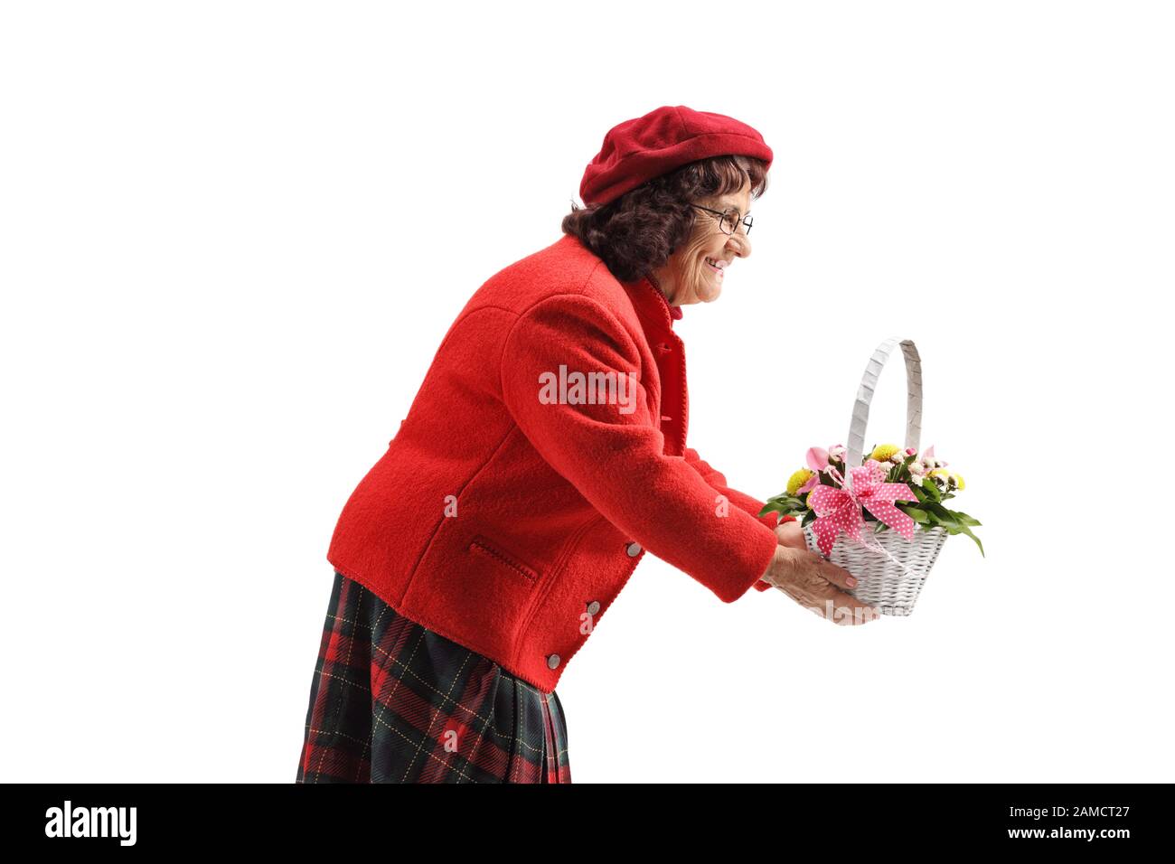 Senior woman giving a basket of flowers isolated on white background ...