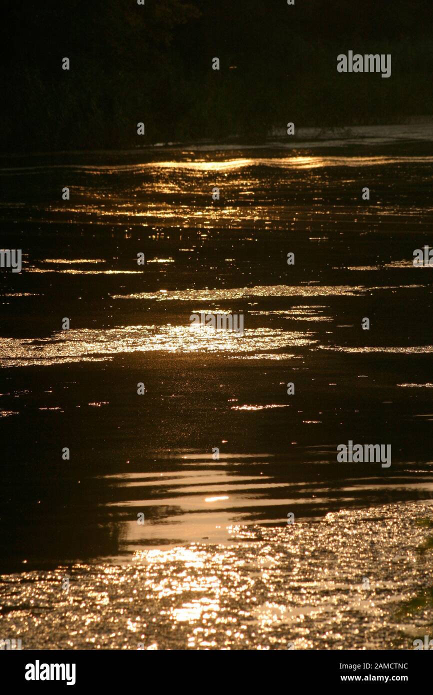 Sun light reflection on the lake's waters, during sunset Stock Photo ...