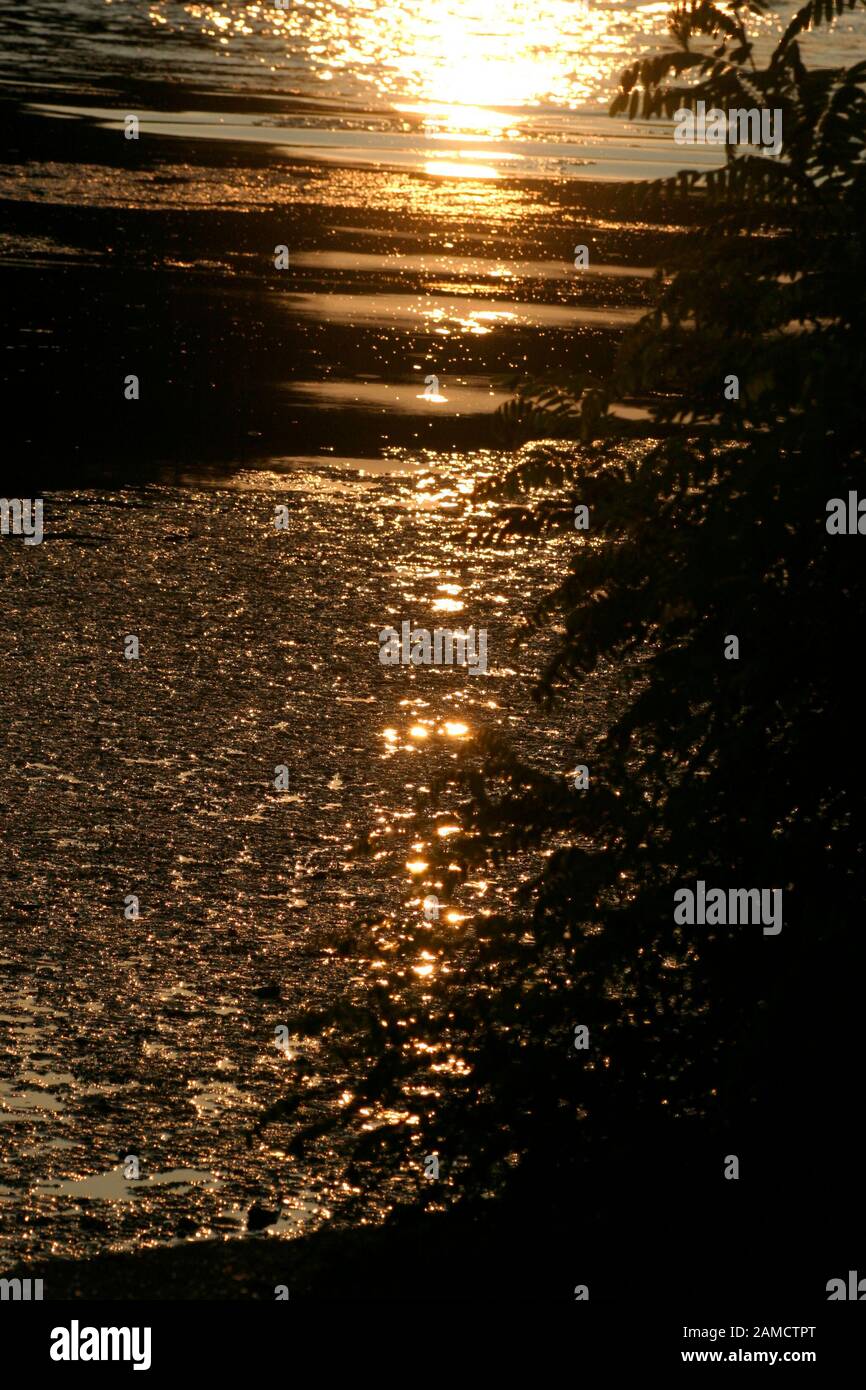 Sun light reflection on the lake's waters, during sunset Stock Photo ...