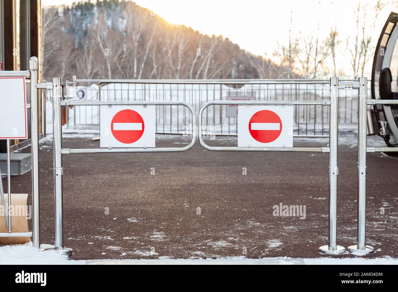 Turnstile at the exit of the ski lift with a stop sign and chrome pipes ...