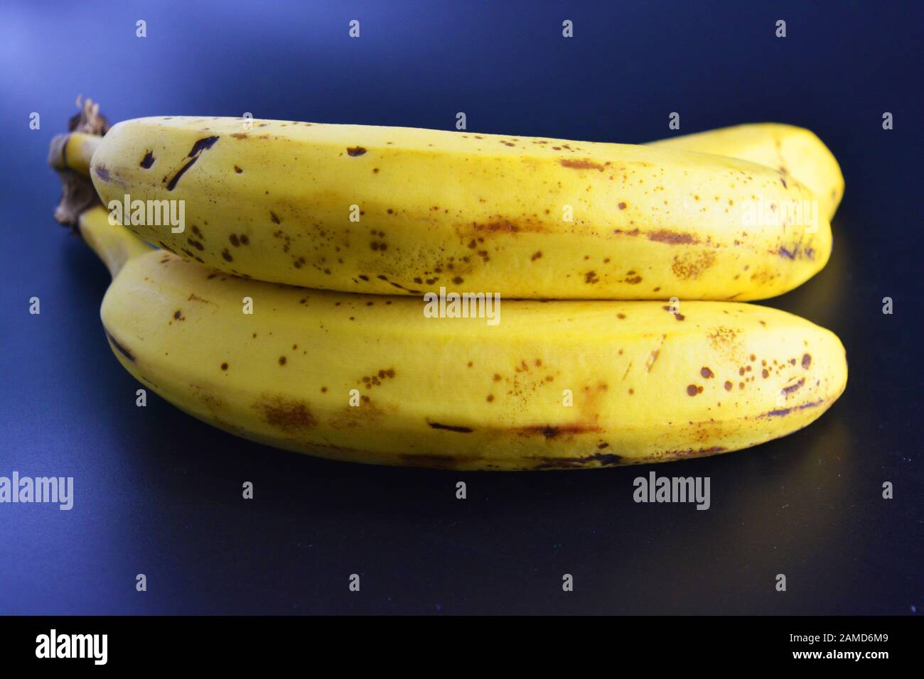 Sweet ripe yellow bananas, a bunch of three bananas with black pegmet ...