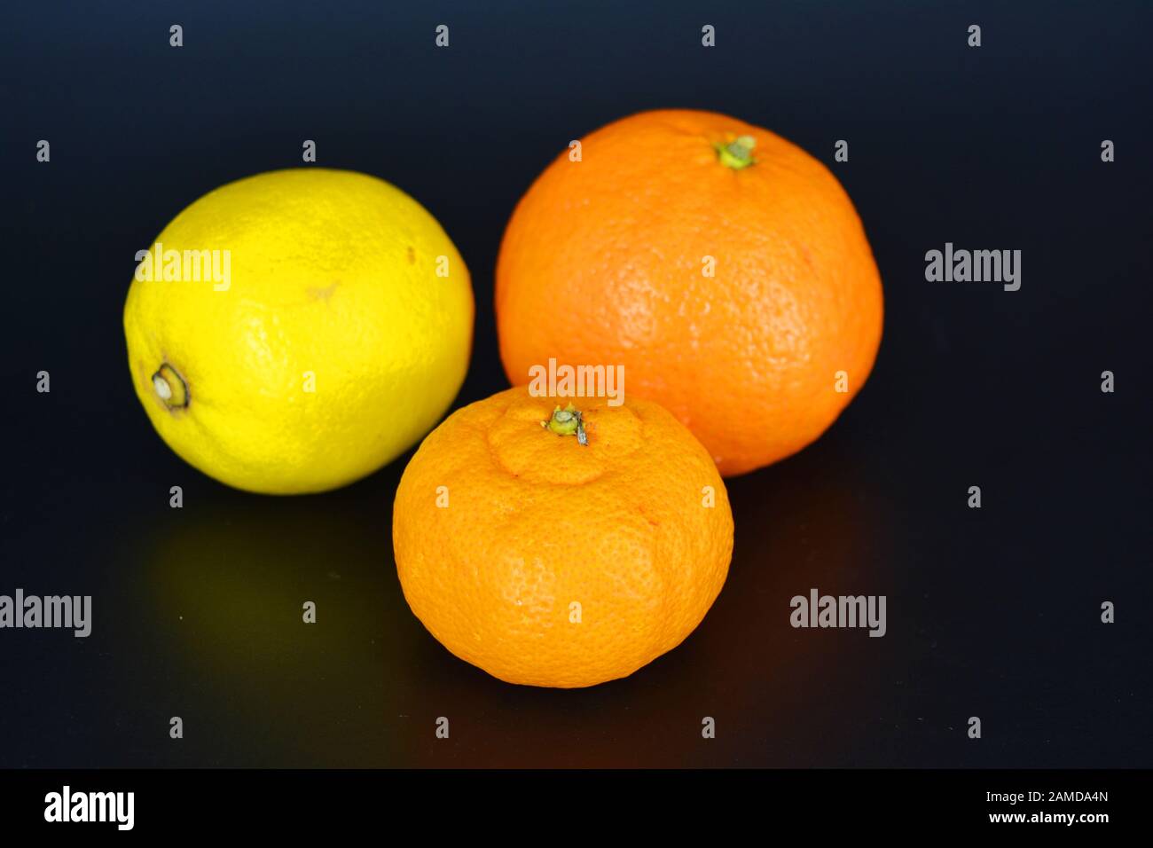 Fresh bright fruit, one yellow lemon, one small orange mandarin, one ...