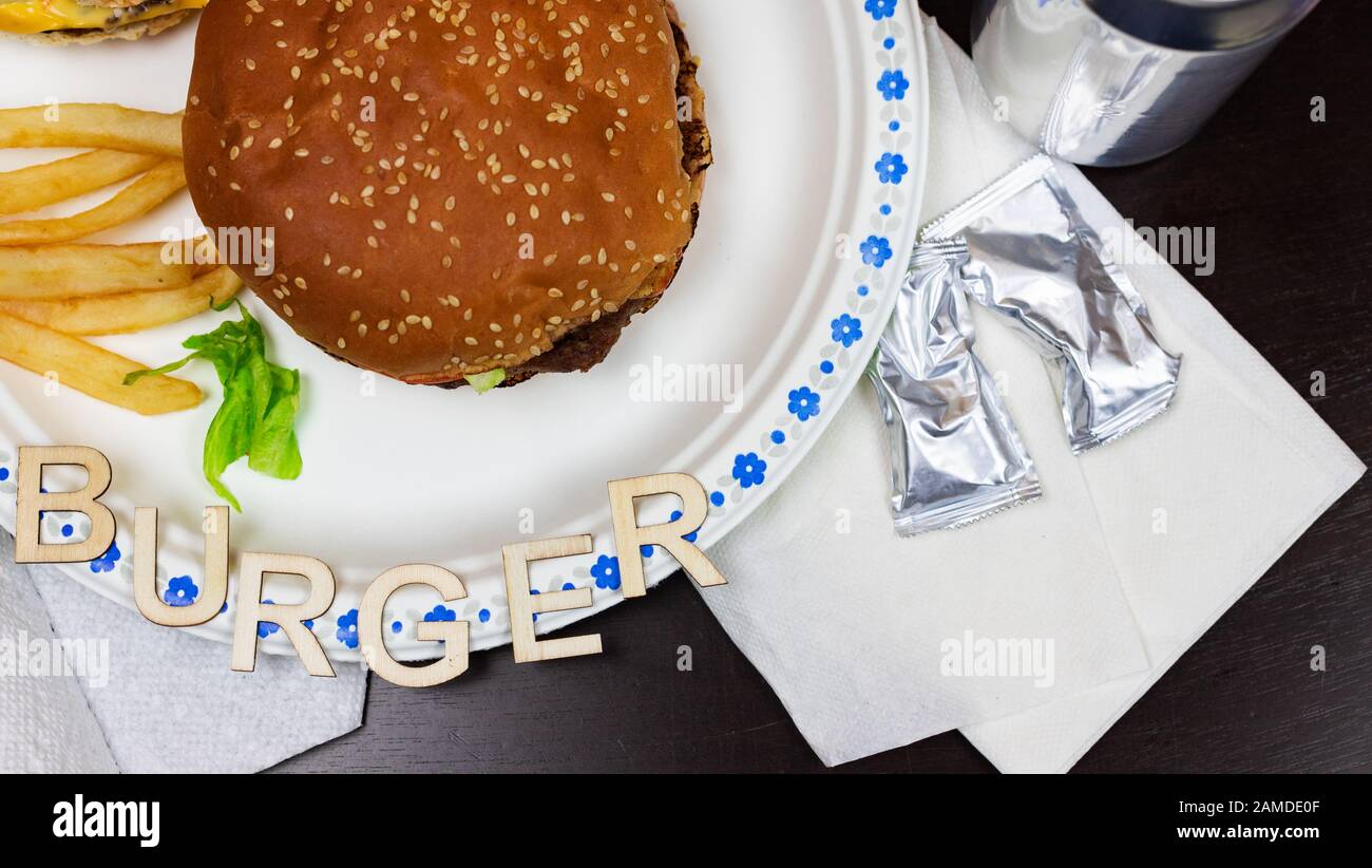 Delicious burger with fries on a white plate. Word burger on the plate ...
