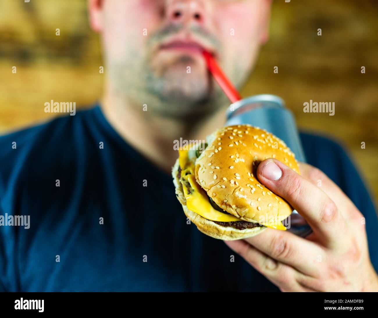 Man with burger and can of pop drink Stock Photo - Alamy
