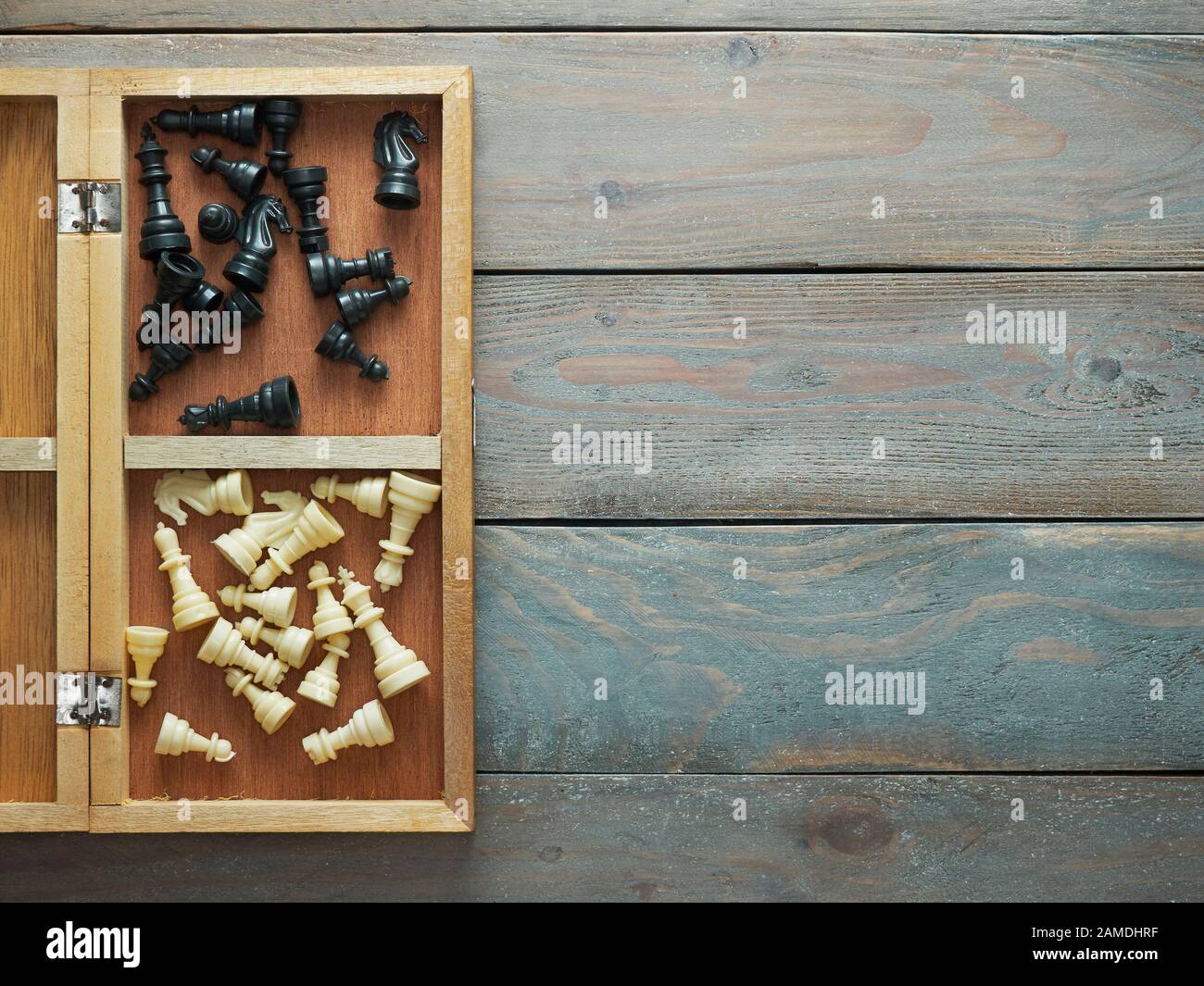 Black and white chess pieces in a chess box with a wooden background ...