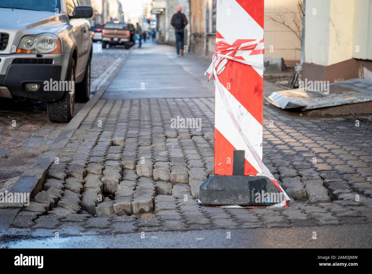 Damaged pedestrian sidewalk. Water flushed, invaded and poor quality ...
