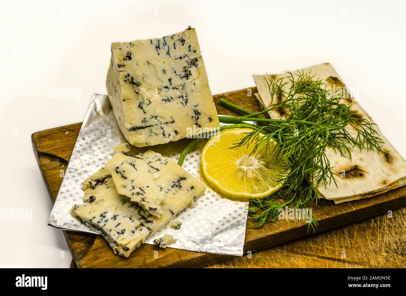 Cutting board with sliced soft cheese with a noble blue mold with a ...