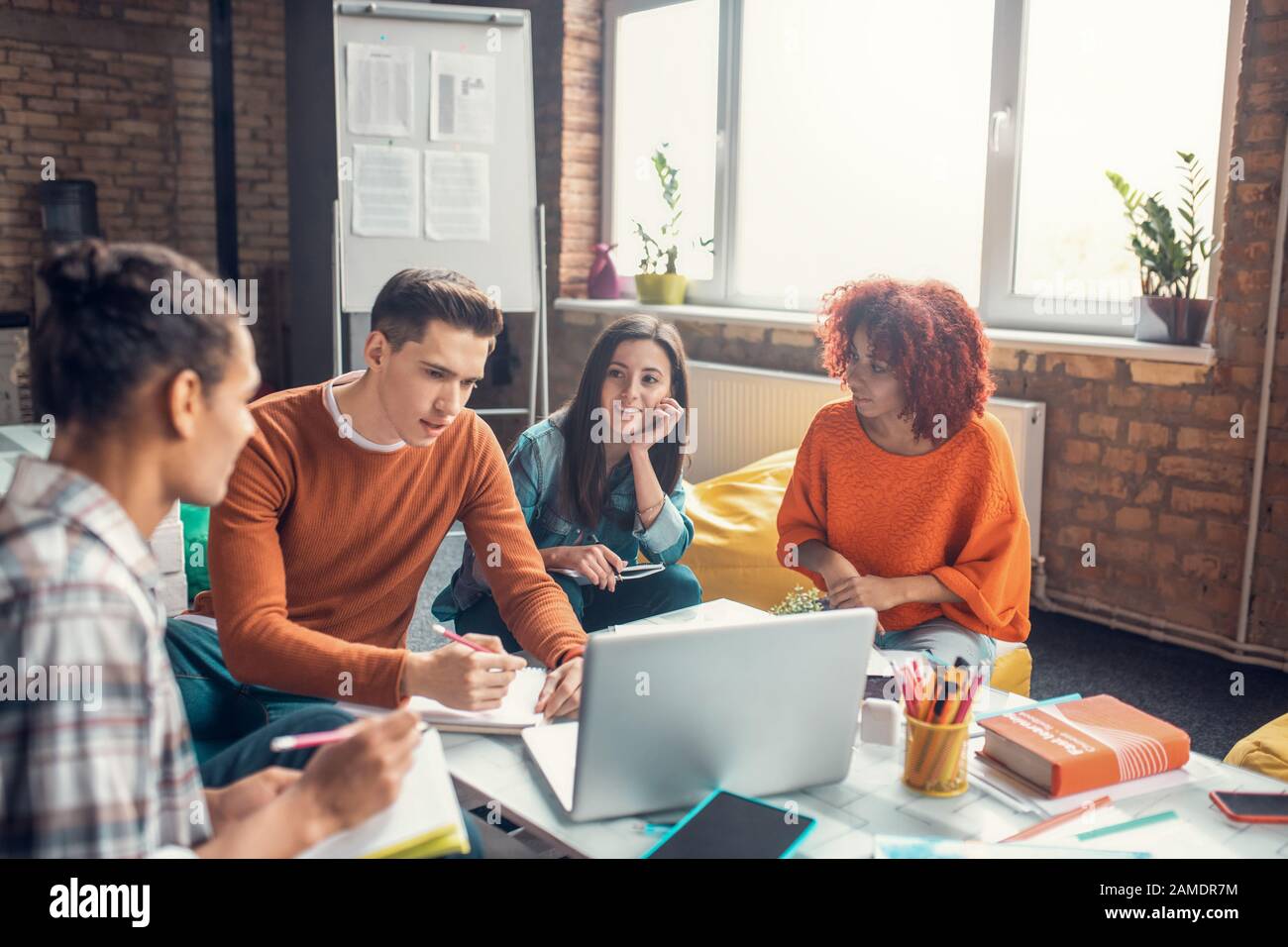 Busy students studying hard while preparing for group project together ...