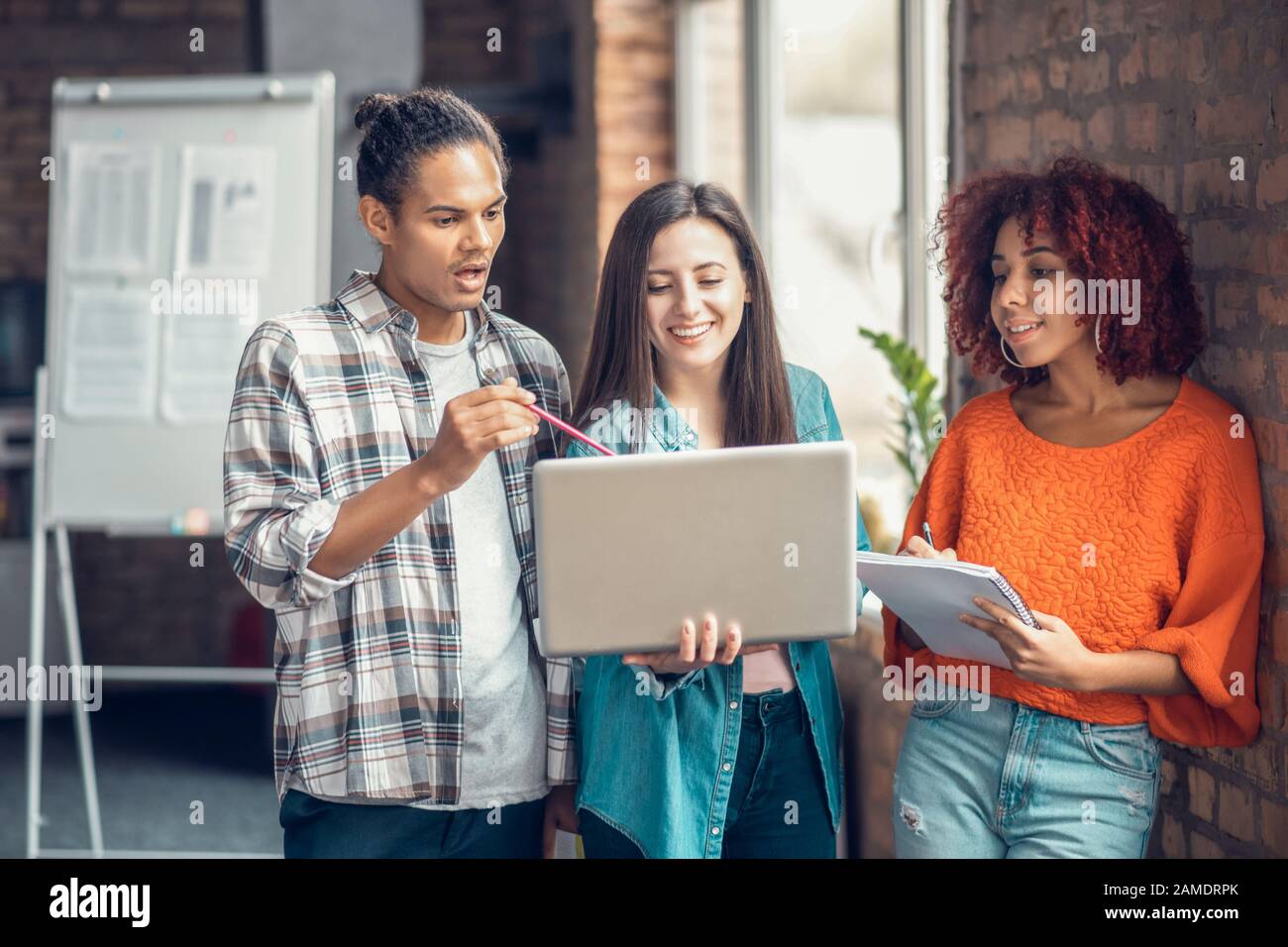 Three smiling students watching webinar and studying together Stock ...