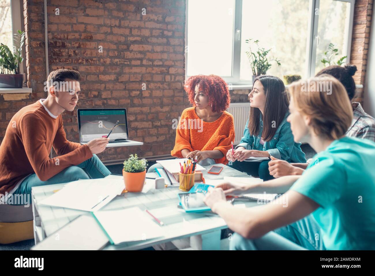Student presenting his ideas with friends while having group project ...