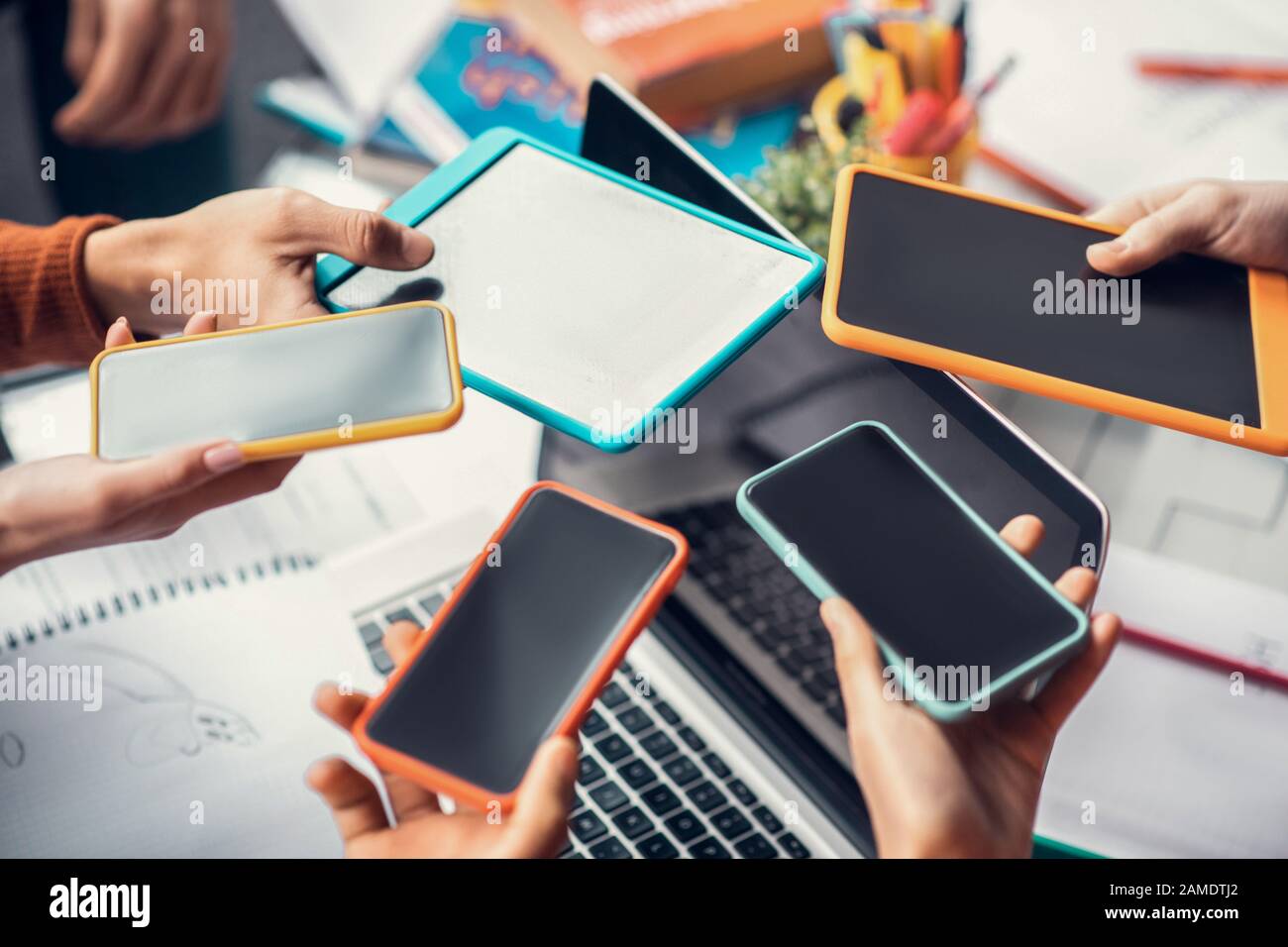 Students holding their phones and tablets while using gadgets for study ...