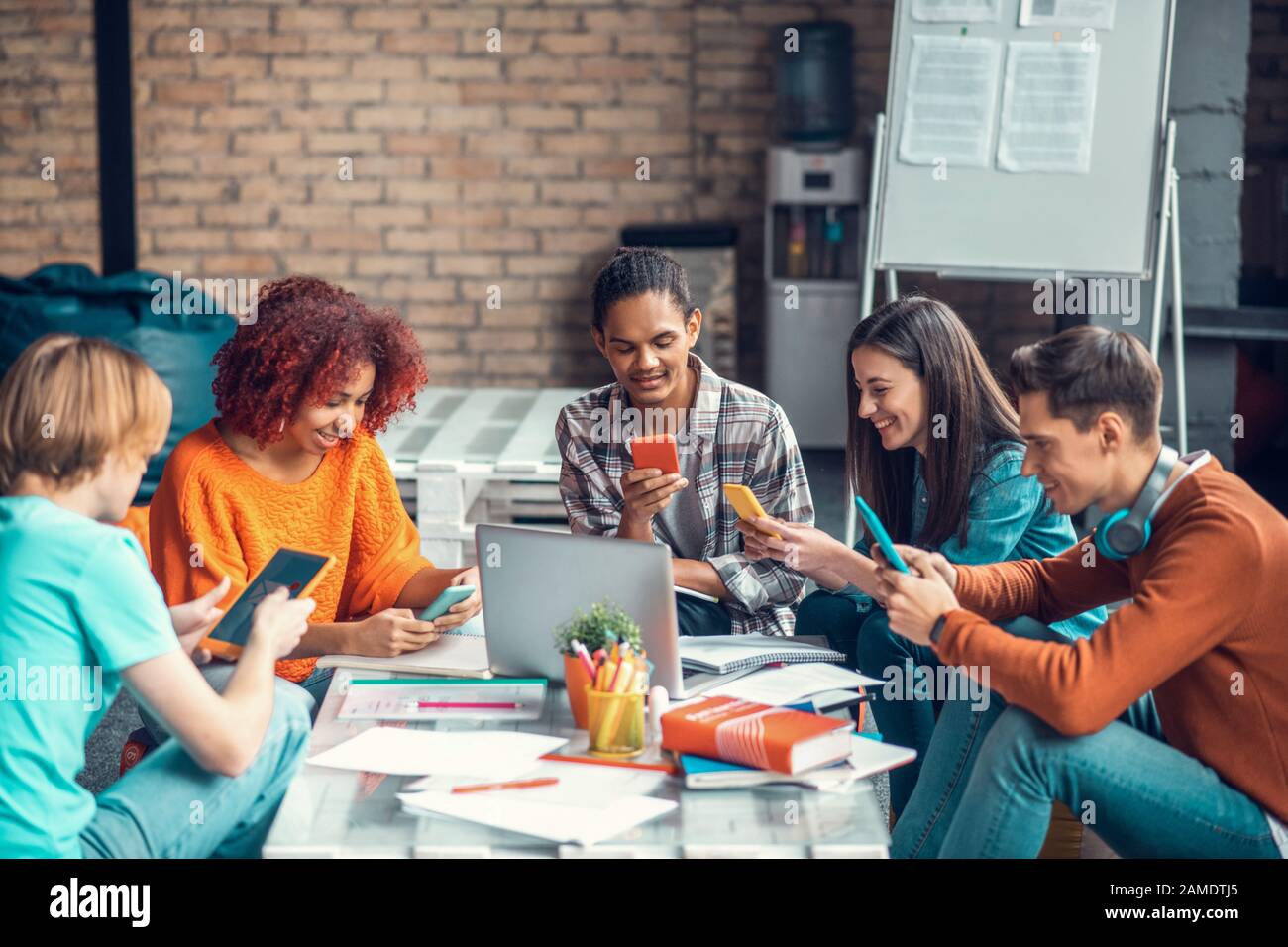 Students using their gadgets while having little break Stock Photo - Alamy