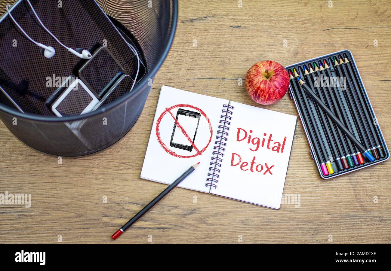 Digital detox message on note pad on desk next to devices, tablet and ...