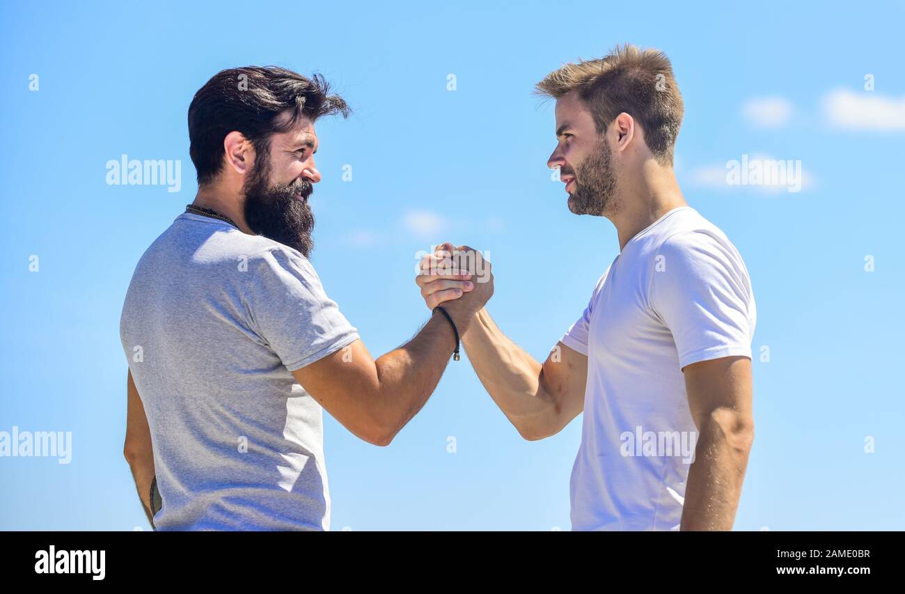 Strong and muscular arms. Successful deal handshake blue sky background ...