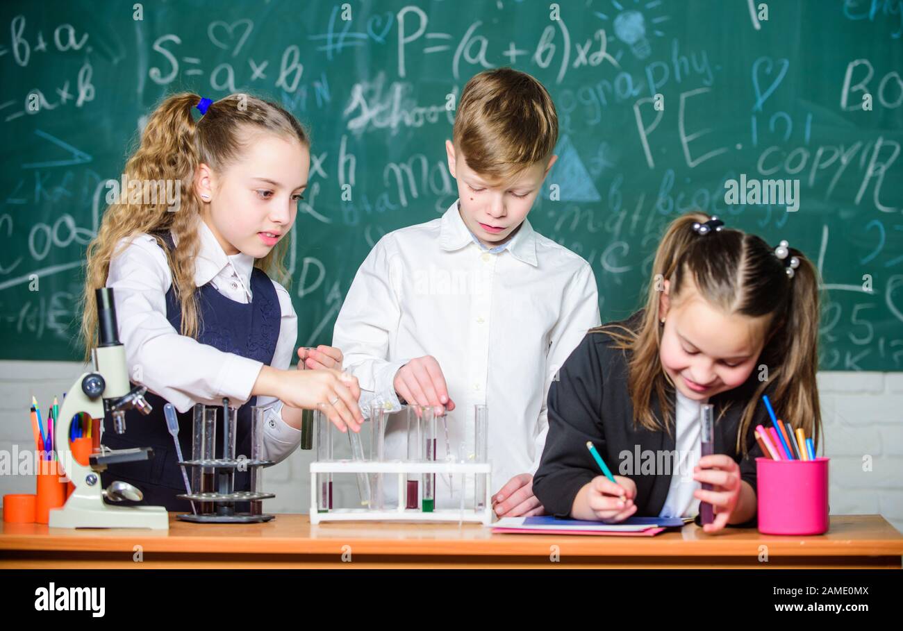 Formal education. Girls and boy student conduct school experiment with ...