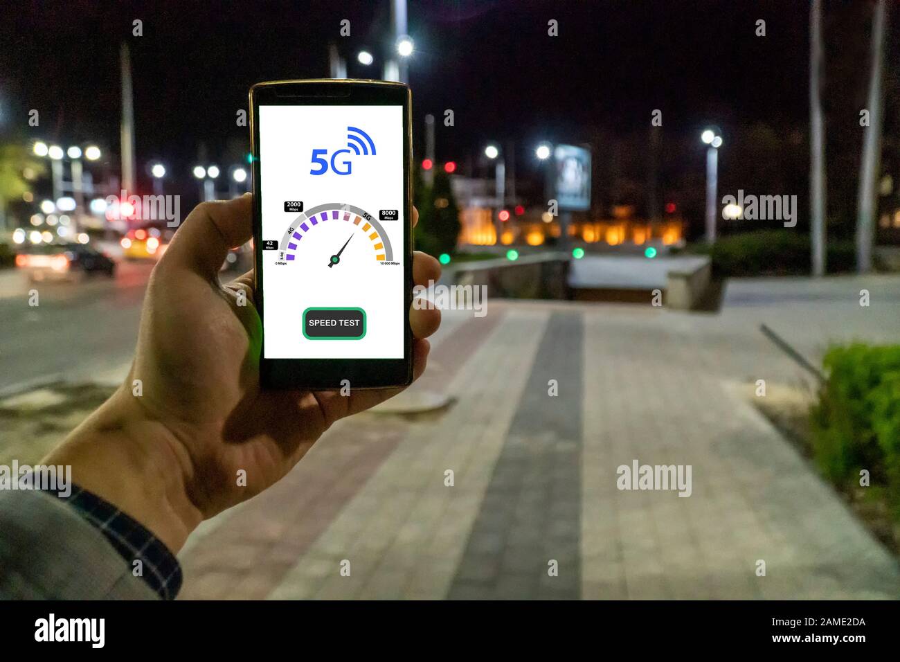 5g network street speed test. Man holding a smartphone outside and ...