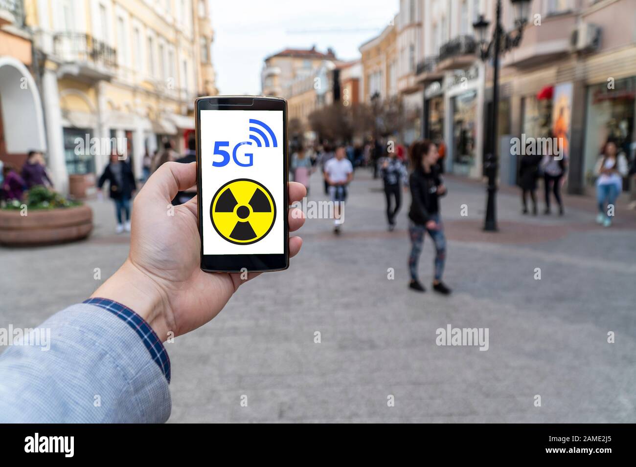 5g network danger on the street. Man holding smartphone with 5g and ...