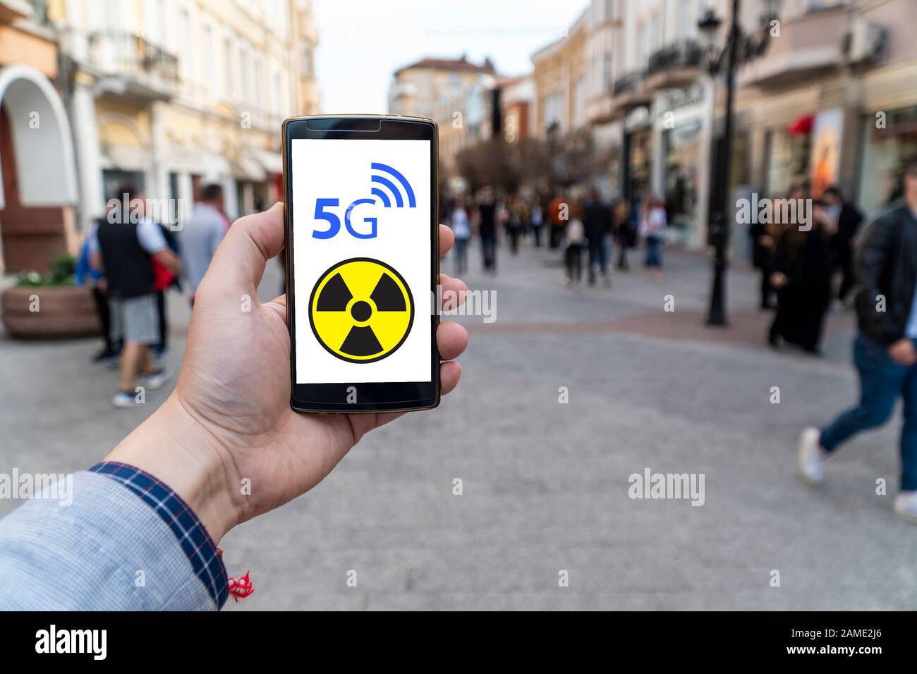 5g network danger on the street. Man holding smartphone with 5g and ...
