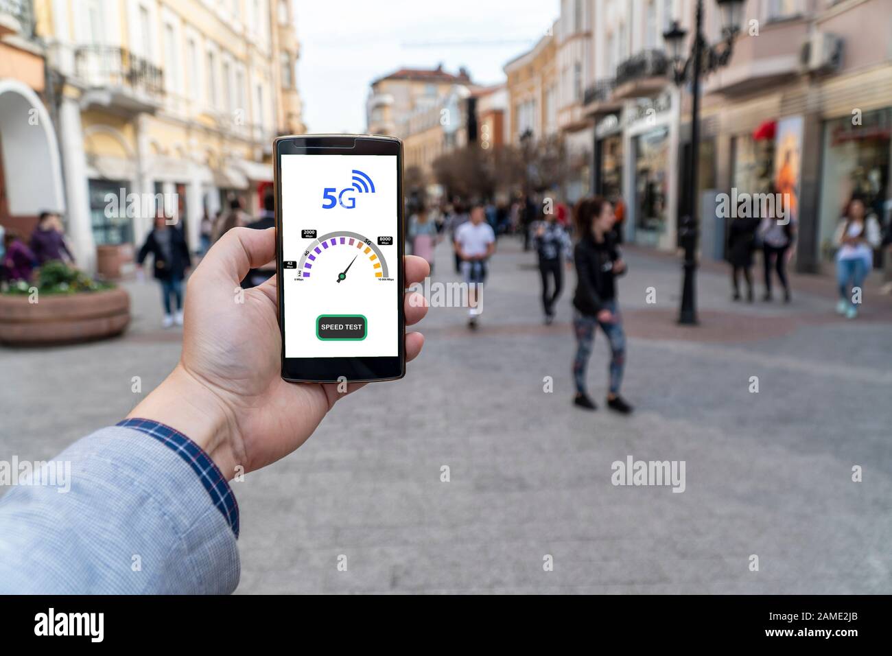 5g network street speed test. Man holding a smartphone outside and ...