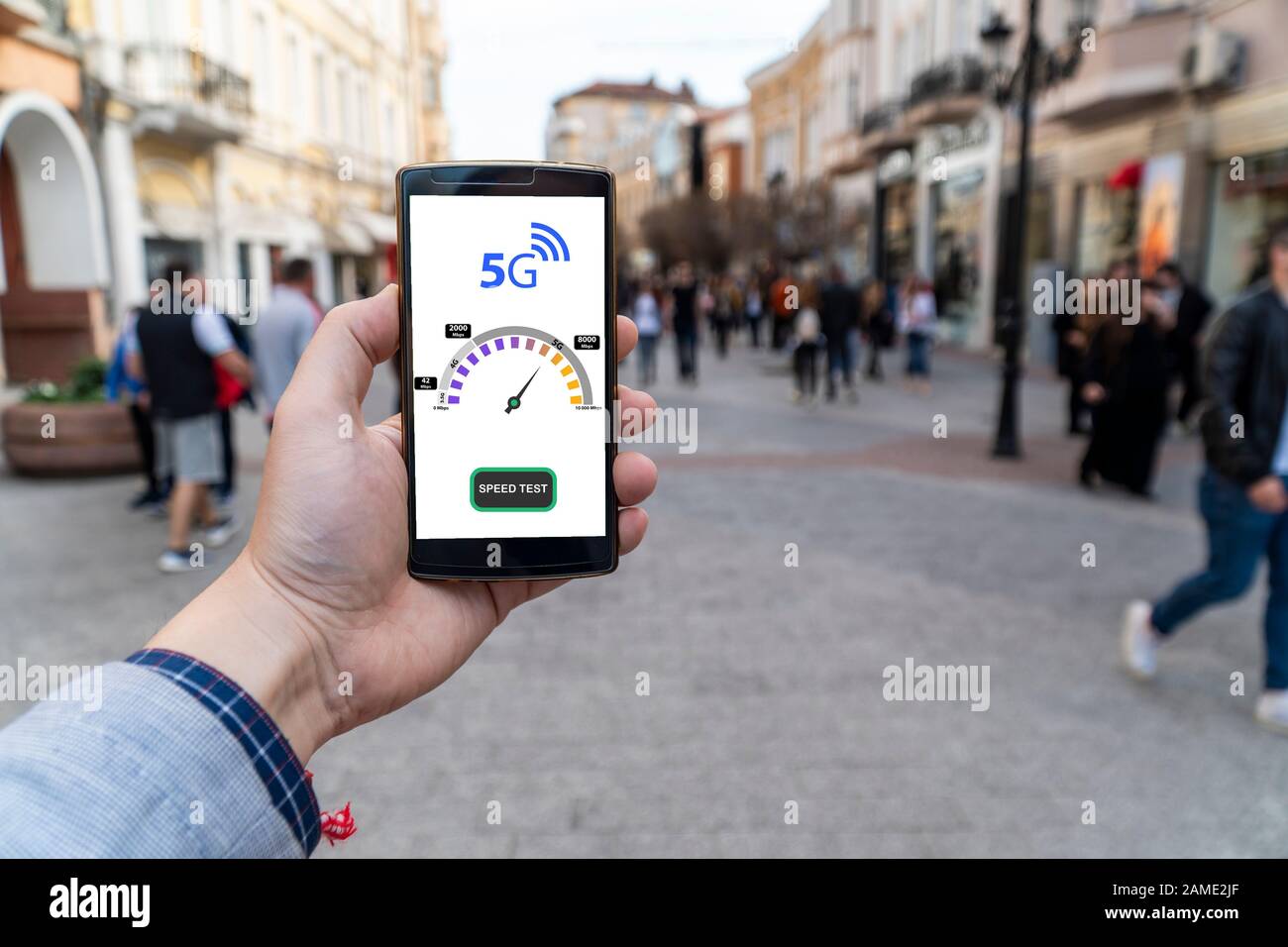 5g network street speed test. Man holding a smartphone outside and ...