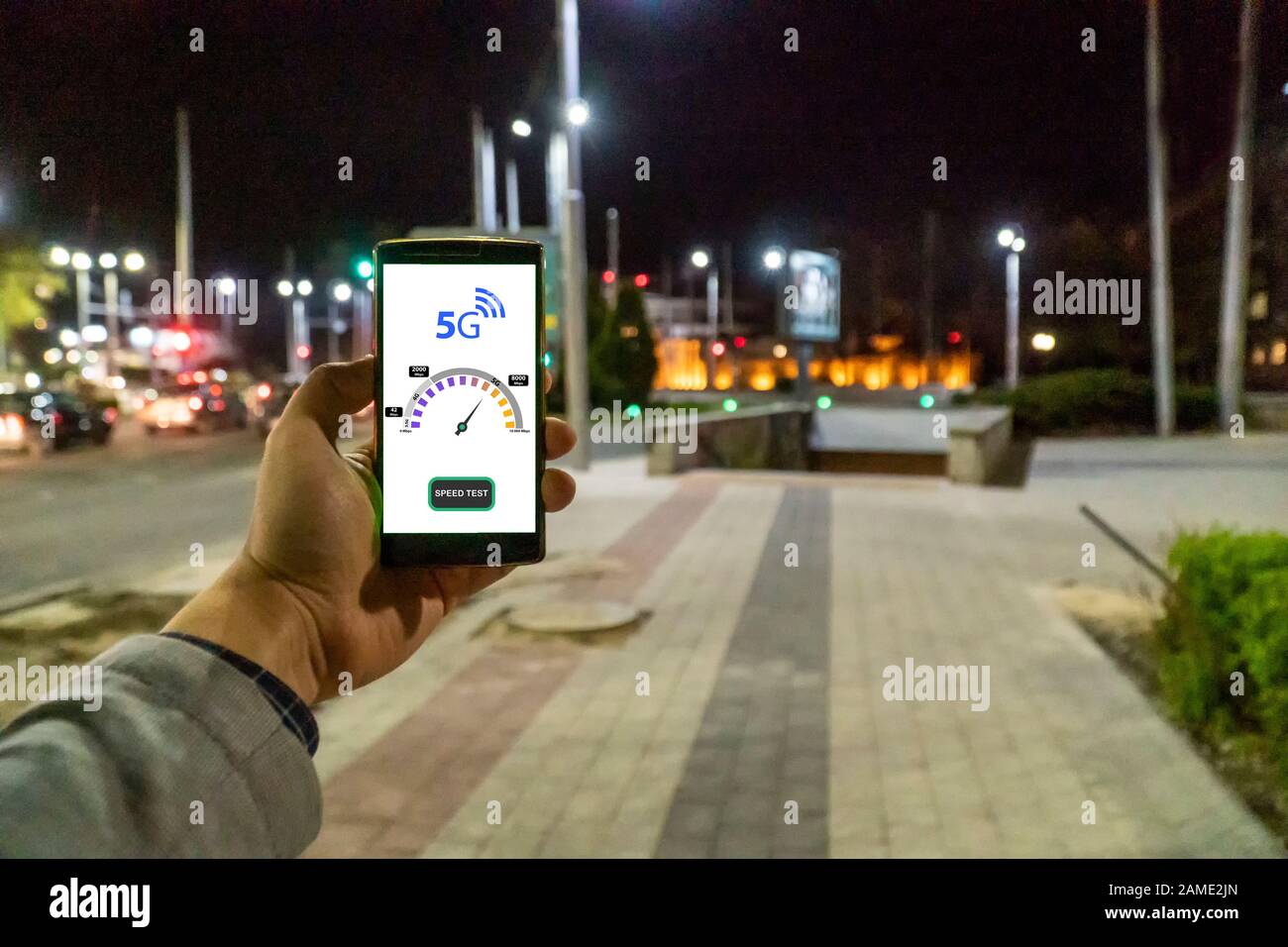 5g network street speed test. Man holding a smartphone outside and ...