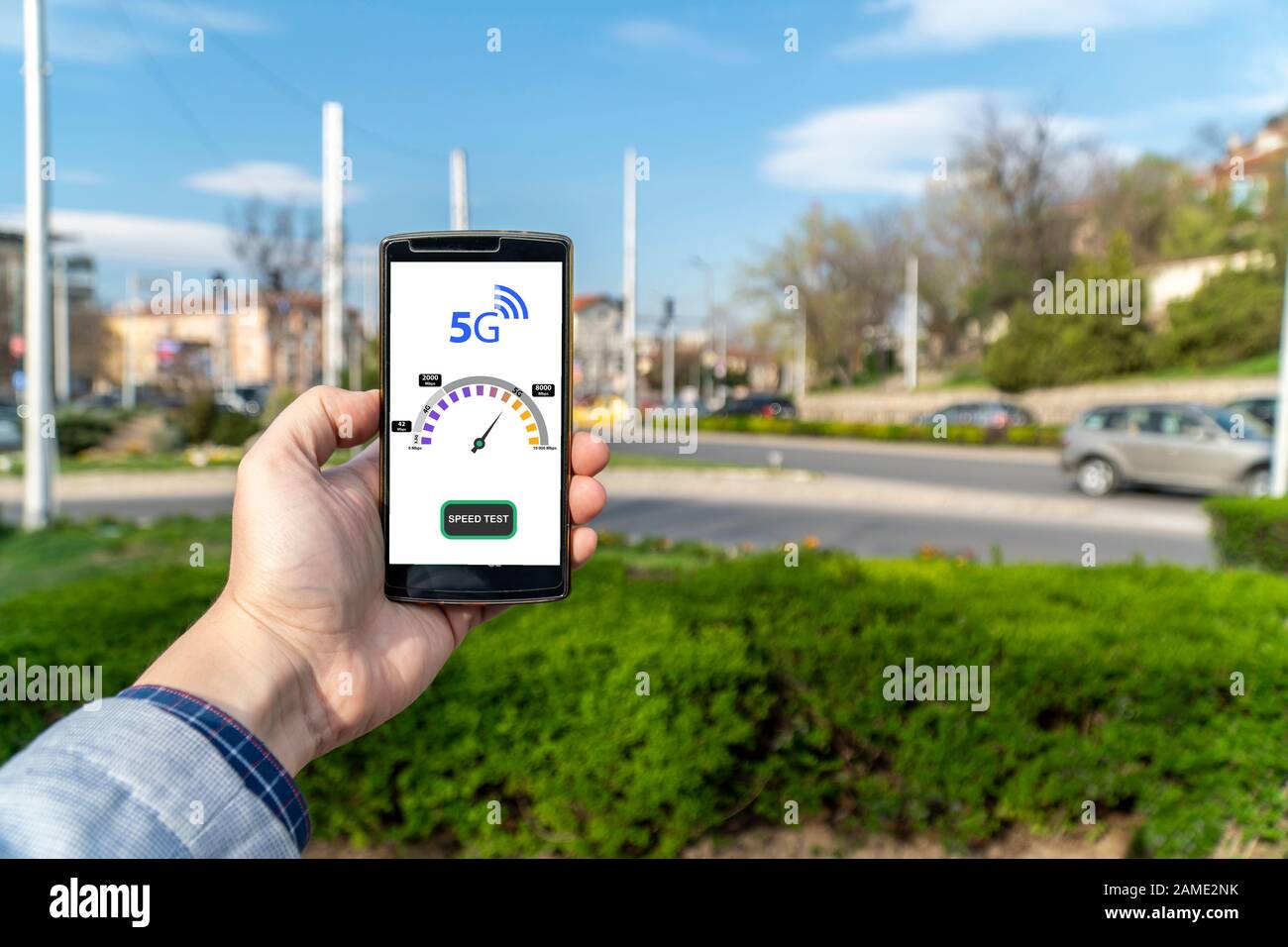 5g network street speed test. Man holding a smartphone outside and ...