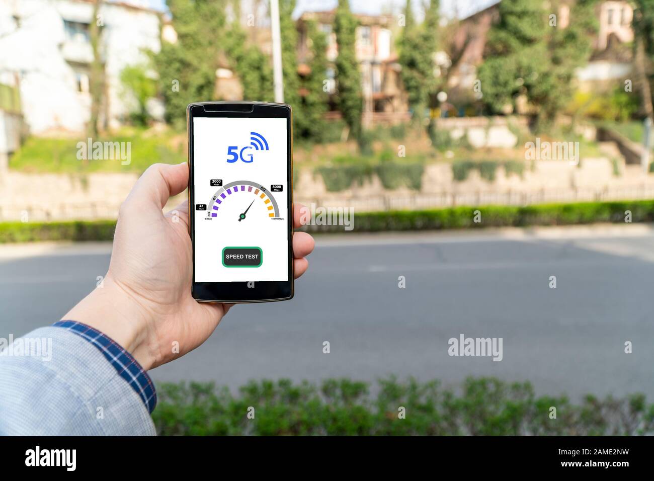 5g network street speed test. Man holding a smartphone outside and ...