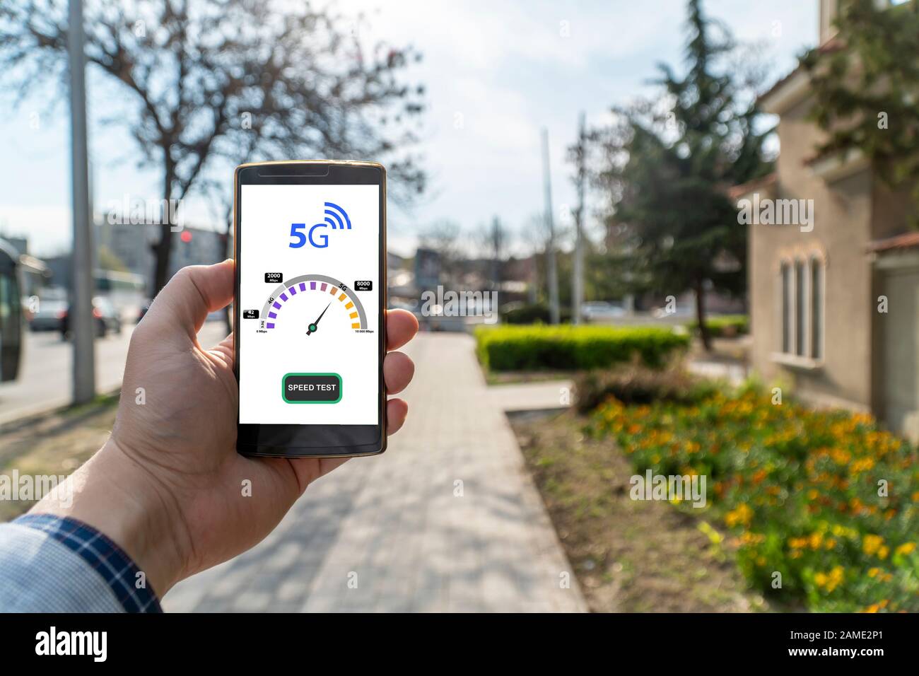 5g network street speed test. Man holding a smartphone outside and ...