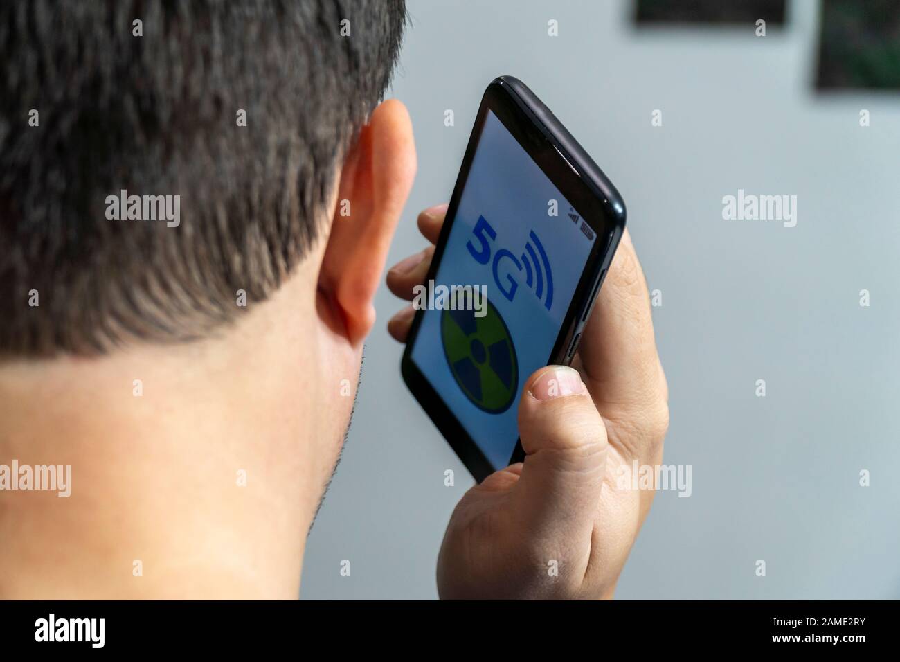 5g network danger concept. Man putting a smartphone to his ear. Back ...