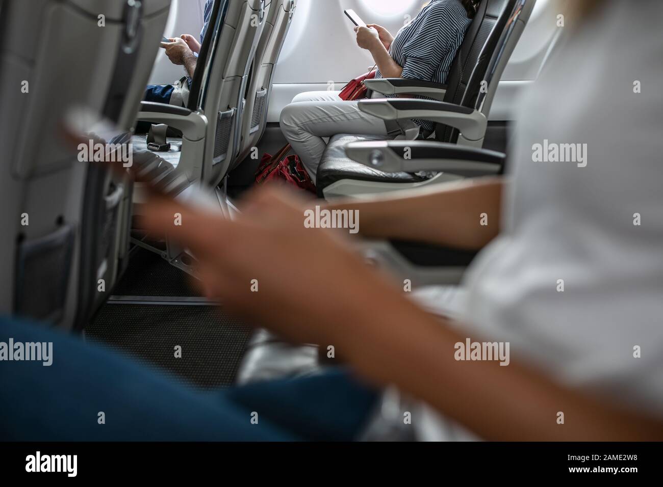 Passengers in abord a commercial flight using their cell phones during ...